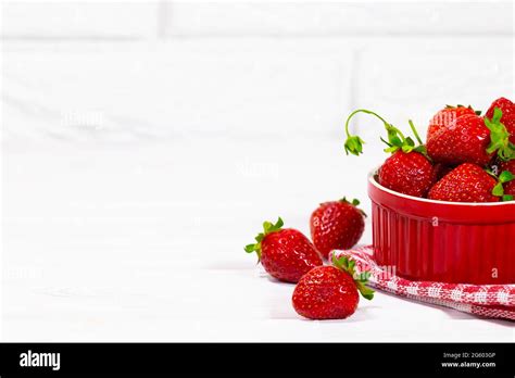 Juicy Fresh Strawberries In A Red Bowl On A White Brick Background