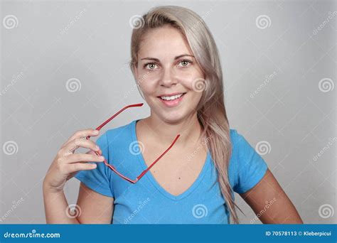 Portrait Of Attractive Woman Wearing Blue Shirt Holding Glasses Stock