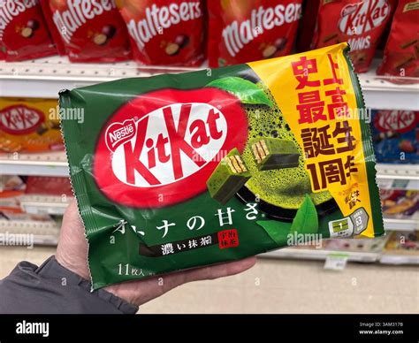 A Hand Holding A Kit Kat Matcha Green Tea Flavor From Japan In Its Original Packaging Stock