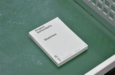 A White Book Sitting On Top Of A Green Table Next To A Metal Grate