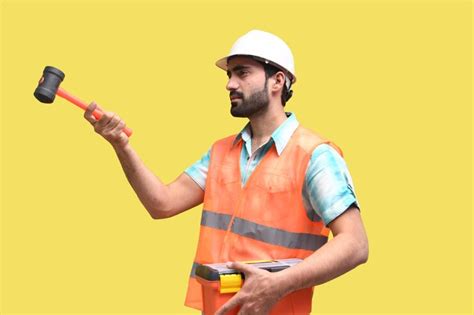 노란색 배경 위에 도구 상자와 망치를 들고 건설 노동자 인도 파키스탄 모델 프리미엄 사진
