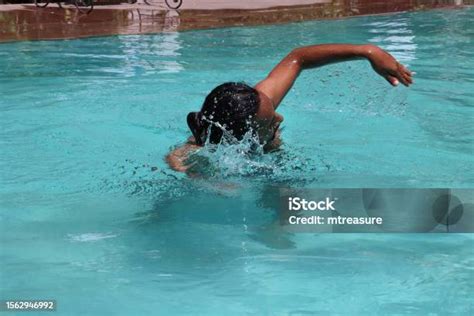 수정처럼 맑은 물 야외 수영장 잔물결에 의해 왜곡된 청록색 파란색 모자이크 타일 수영과 튀는 소리 고르지 못한 수면 반사 전경에 초점을 맞춘 인도 남자의 클로즈업 이미지