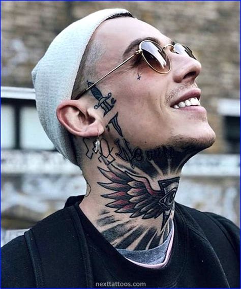 A Man With Tattoos On His Face And Neck Looking Up At The Sky While Wearing Sunglasses
