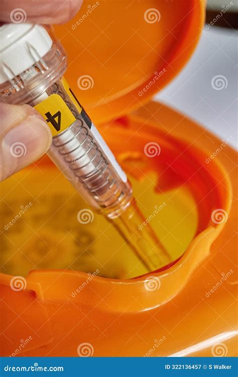 Disposing Of A Used Heparin Retractable Syringe Into A Sharps Bin