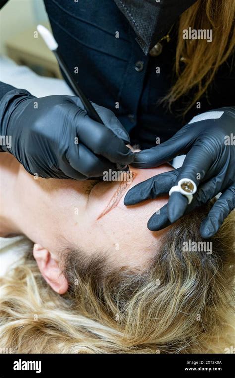 This Image Captures A Beautician Meticulously Performing A Microblading