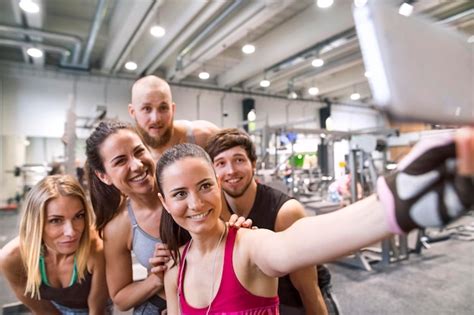 Jóvenes atletas divirtiéndose en el gimnasio tomando selfies Foto Premium