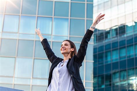 비즈니스 슈트를 입은 사업가 거래를 마친 후 행복에 기뻐하며 배경 마천루에서 공중에서 그녀의 손을 가진 Bu8siness 여자 사업가에 대한 스톡 사진 및 기타 이미지