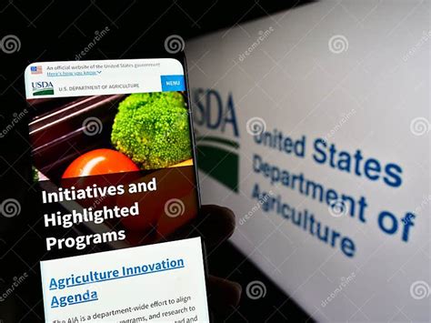 Person Holding Cellphone With Webpage Of United States Department Of