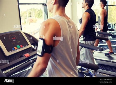 Smiling Men Exercising On Treadmill In Gym Stock Photo Alamy