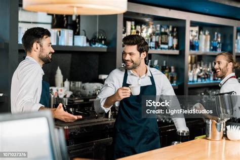마시는 커피와 직장에서 동료 들과 함께 말하기 잘생긴 쾌활 한 바텐더 남자에 대한 스톡 사진 및 기타 이미지 남자 동료