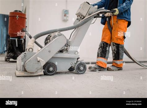 Workers Grind The Concrete Floor At The Construction Site Prepares The