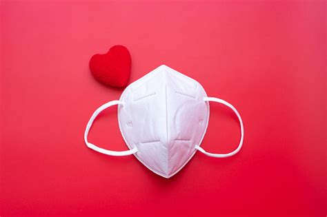 코로나바이러스 질병 감염에 대한 붉은 배경에 심장 모양 장식 및 N95 의료 얼굴 마스크 사랑 함께 해피 발렌타인 데이 에 따라