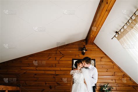 相爱的夫妇，新娘和新郎在室内拥抱和亲吻。婚礼的早晨。