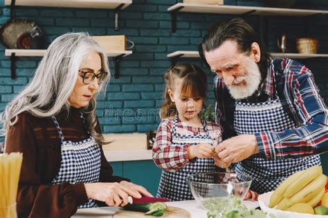 Abuelos Mayores Pareja Con Nieta Cocinando En La Cocina Foto De Archivo