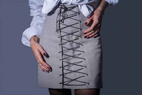 모델에 흰색 셔츠와 함께 앞에 고품질의 직물과 장식 레이스로 만든 회색 디자이너 스커트의 클로즈업 어두운 회색 배경에 옷의 카탈로그 사진 갈색 머리에 대한 스톡 사진 및