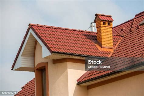 가파른 지붕된 빨간 지붕 높은 벽돌 굴뚝 치장 용 벽 토 벽과 푸른 하늘 복사 공간 배경에 다락방 창 큰 현대 비싼 주거 집 별장의 탑 미래의 개념에 투자입니다 건설 산업에