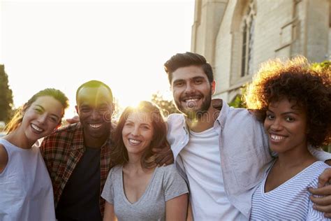 Groupe De Jeunes Amis Adultes De Sourire Embrassant Dans La Rue Photo