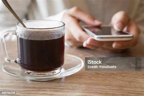 점심 시간에 카페에서 테이블에 검은 커피를 마시는 젊은 여자 휴대 전화를 들고 텍스트를 읽는 손 커피 휴식 0명에 대한 스톡 사진 및 기타 이미지 Istock