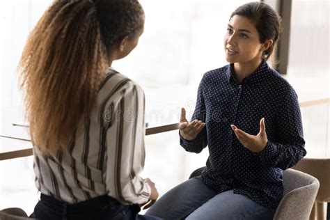Two Women Engaged In Conversation Discussing Joint Work Related Topics