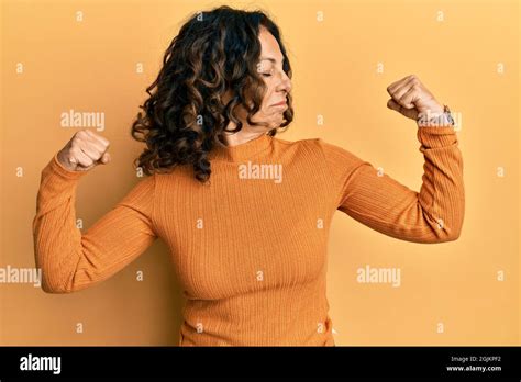 Middle Age Hispanic Woman Wearing Casual Clothes Showing Arms Muscles