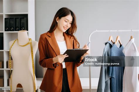 테일러링 아틀리에에서 옷을 만드는 아시아 재단사 여성 아름다운 젊은 여성 패션 디자이너가 미소를 짓고 현대 스튜디오에서 성공한
