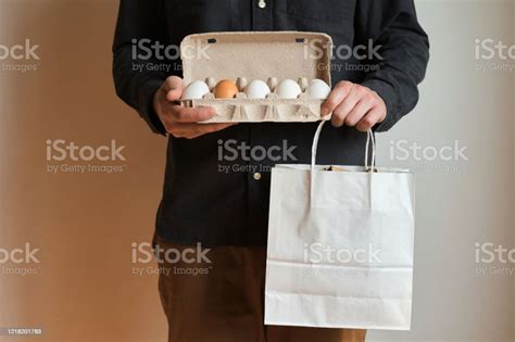 치킨 계란 골판지 상자입니다 한 남자가 조리되지 않은 달걀이 있는 상자를 들고 있다 천연 유기농 농장 제품 부활절 휴일준비