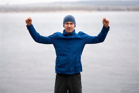 Homme Debout Près Du Lac Avec Les Bras En Lair Photo Gratuite