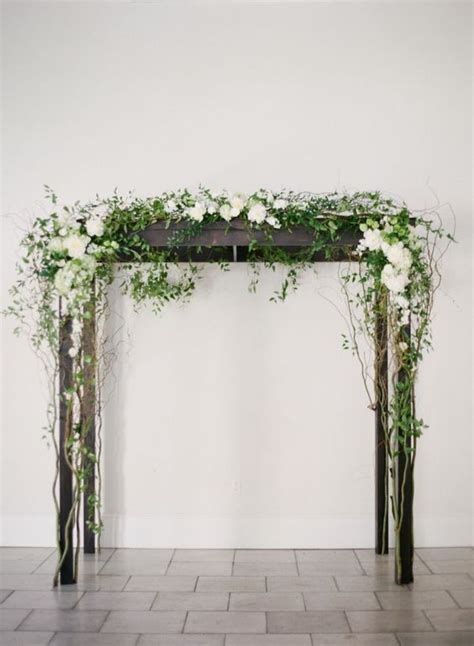 Picture Of Dark Wood Arbor Decorated With White Flowers And Greenery
