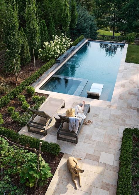 Top Down View Of A Woman Relaxing Poolside With A Book By Stocksy