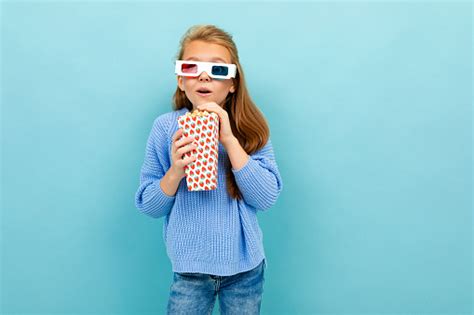 3d 영화와 팝콘 양동이 안경과 파란색 배경에 쾌활한 세련된 소녀의 절반 길이 샷 놀라움에 대한 스톡 사진 및 기타 이미지