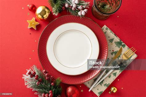 크리스마스 축하를 위한 우아한 휴일 저녁 식사 테이블 설정 접시 황금 식기 냅킨 와인 잔 장식품 색종이 조각 젖빛 전나무