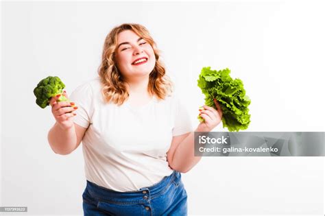 연한 회색 배경에 밝은 감정을 가진 아름 다운 뚱뚱한 젊은 여자 다이어트의 개념입니다 텍스트에 대 한 공간입니다 건강한 식생활에