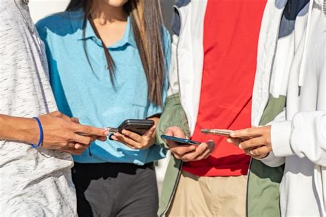 Grupo De Amigos Adolescentes Felizes Olhando Seus Telefones E Rindo Na Rua Da Cidade Foto Premium