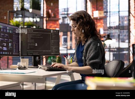 African American Software Engineer Works On Dual Monitors And Typing Code For A Development