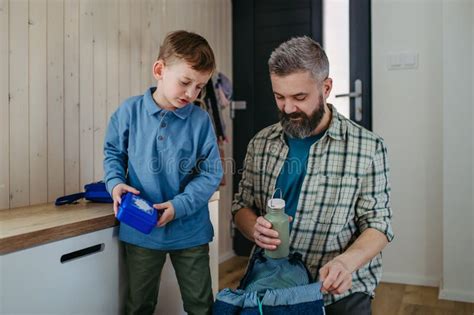 Padre Ayudando A Su Hijo A Prepararse Para El Preescolar Poner La