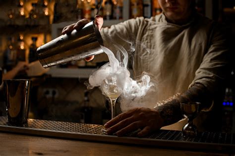 셰이커 컵에서 와인 잔에 김이 나는 음료를 쏟아 붓는 바텐더의 전망 강철에 대한 스톡 사진 및 기타 이미지 강철 귀여운