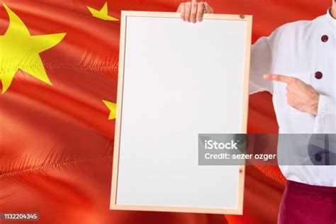 중국 국기 배경에 빈 화이트 보드 메뉴를 들고 중국 요리사 텍스트에 대 한 균일 한 포인팅 공간을 착용 요리 고급 요리에 대한