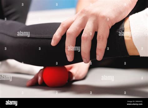 Close Up Of A Male Massage Therapist Showing A Client How To Use And Massage A Ball Myofascial
