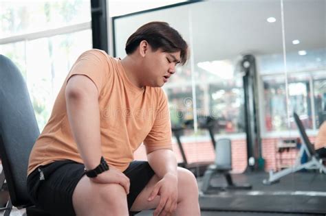 A Man In A Gym Is Sitting On A Bench He Is Tried And Rest After