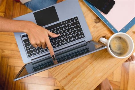 Premium Photo Top View Of Unrecognizable Woman Touching Laptop Screen With Finger On Table