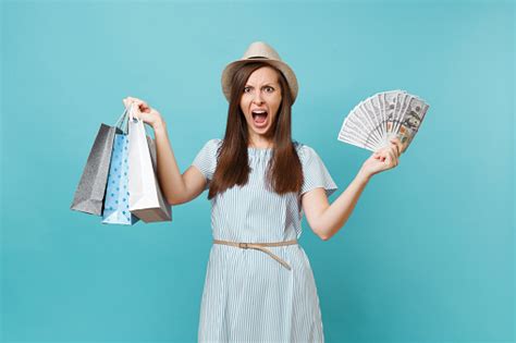 여름 복장 쇼핑 후 구매와 패키지 가방을 들고 밀 짚 모자에에서 초상화 화가 여자 많은 달러 지폐 현금 돈 파란색 배경에 고립 광고에 대 한 공간을 복사 합니다 가방에 대한
