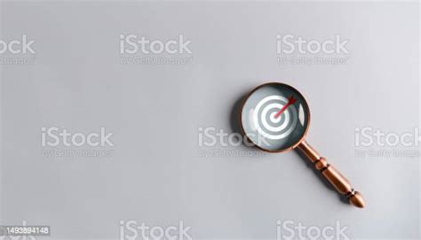 돋보기는 회색 배경에 있는 비즈니스의 다트판 목표와 업적을 확대합니다 초점이 맞춰진 비전은 목표와 비즈니스 성공 개념을