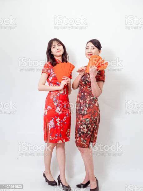 흰색 배경에 중국 새해에 빨간 봉투가있는 전통적인 Cheongsam Qipao 드레스를 입은 아시아 여성의 초상화 2명에 대한