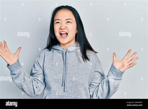 Jeune fille chinoise portant des vêtements décontractés hurlant et fou