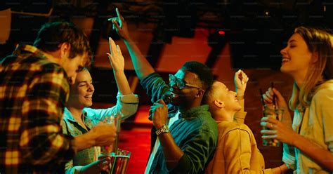 다민족 젊은이들이 밤에 술집에서 노래방에서 노래를 부르며 즐겁습니다 초점은 흑인에게 있습니다 사진 Unsplash의 사람 이미지