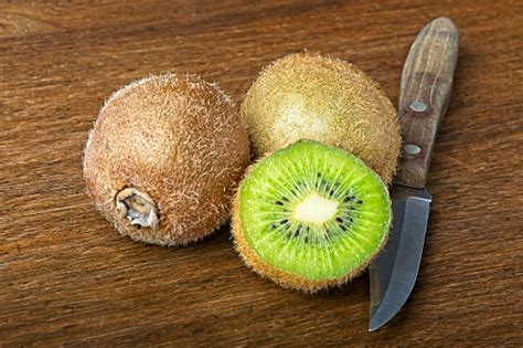 두 개의 신선한 키위 과일과 반 키위가 어두운 나무 부엌 탁상에 오래된 파잉 나이프의 측면에 배치 0명에 대한 스톡 사진 및 기타 이미지 Istock