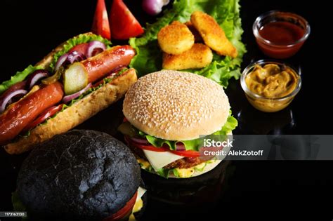 맛있는 패스트 푸드 소고기 버거 커틀릿 튀긴 양파 시금치 케첩 소스 블루 치즈를 전통적인 빵에 곁들인 햄버거 2개가 어두운 나무