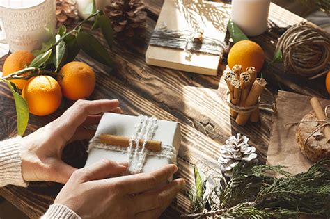 나무 배경에 세련된 아늑한 공예 선물 상자 천연 에스테틱 여자는 제로 폐기물 플라스틱 무료 크리스마스를위한 유행 손 만든 선물 패키지를 만든다 12월에 대한 스톡 사진 및