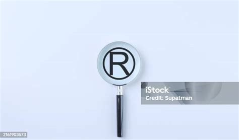 상표 저작권 기호를 등록합니다 돋보기는 흰색 배경에 등록 상표 기호에 초점을 맞추어 상표 등록 및 지적 재산권의 개념을 보여줍니다 0명에 대한 스톡 사진 및 기타 이미지