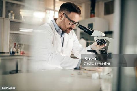 젊은 남성 화학자는 실험실에서 현미경에 자신의 샘플을 조정 생명 공학에 대한 스톡 사진 및 기타 이미지 생명 공학 약